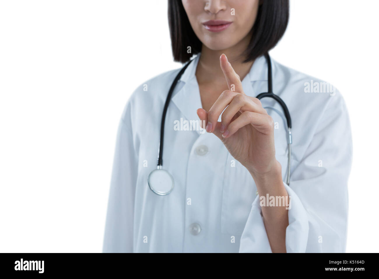 Mid section of female doctor touching invisible screen against white ...