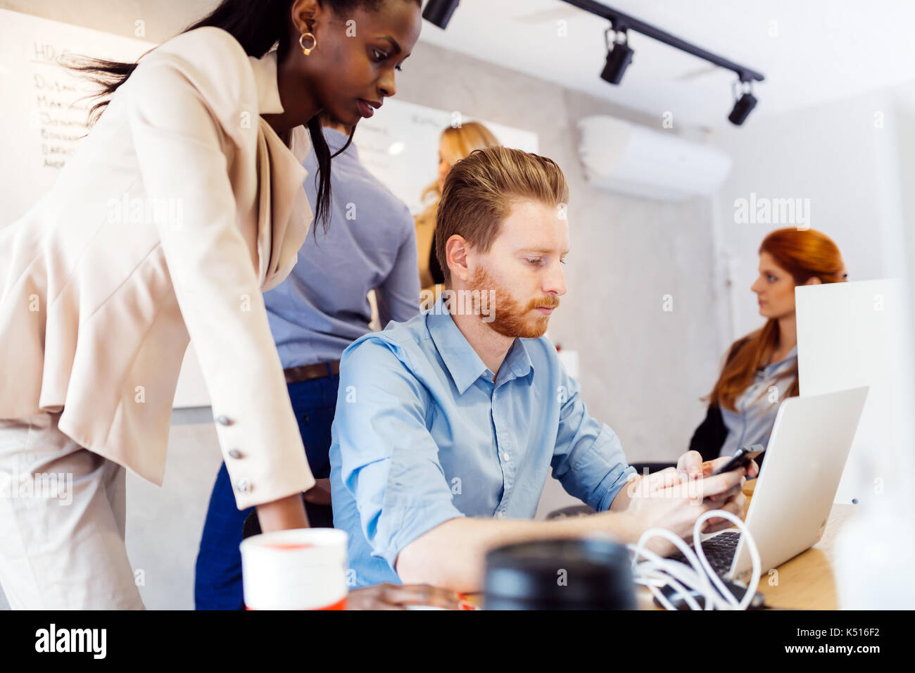 Young manager helping colleague hi-res stock photography and images - Alamy