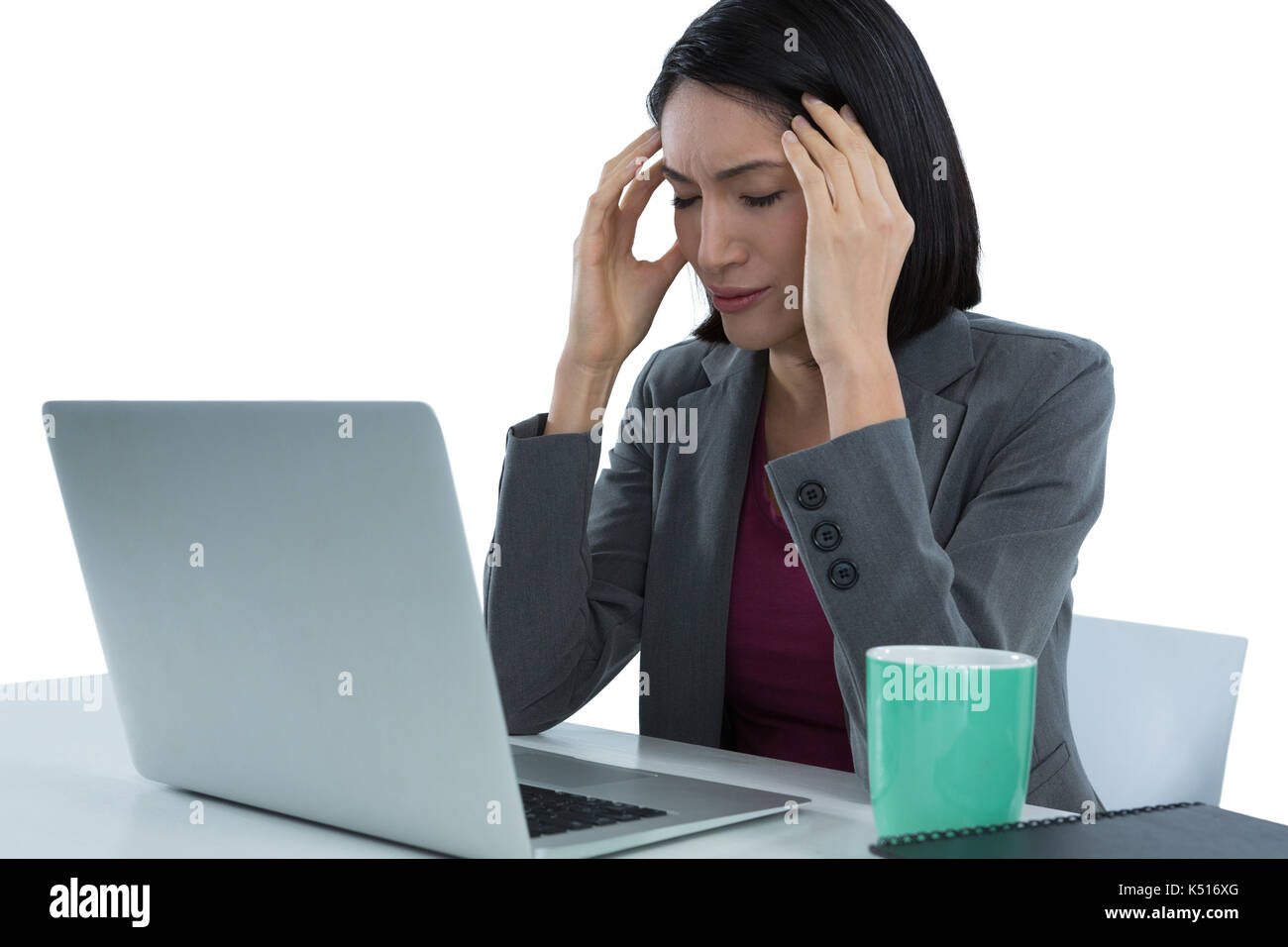 Businesswoman suffering from headache while working at desk Stock Photo ...