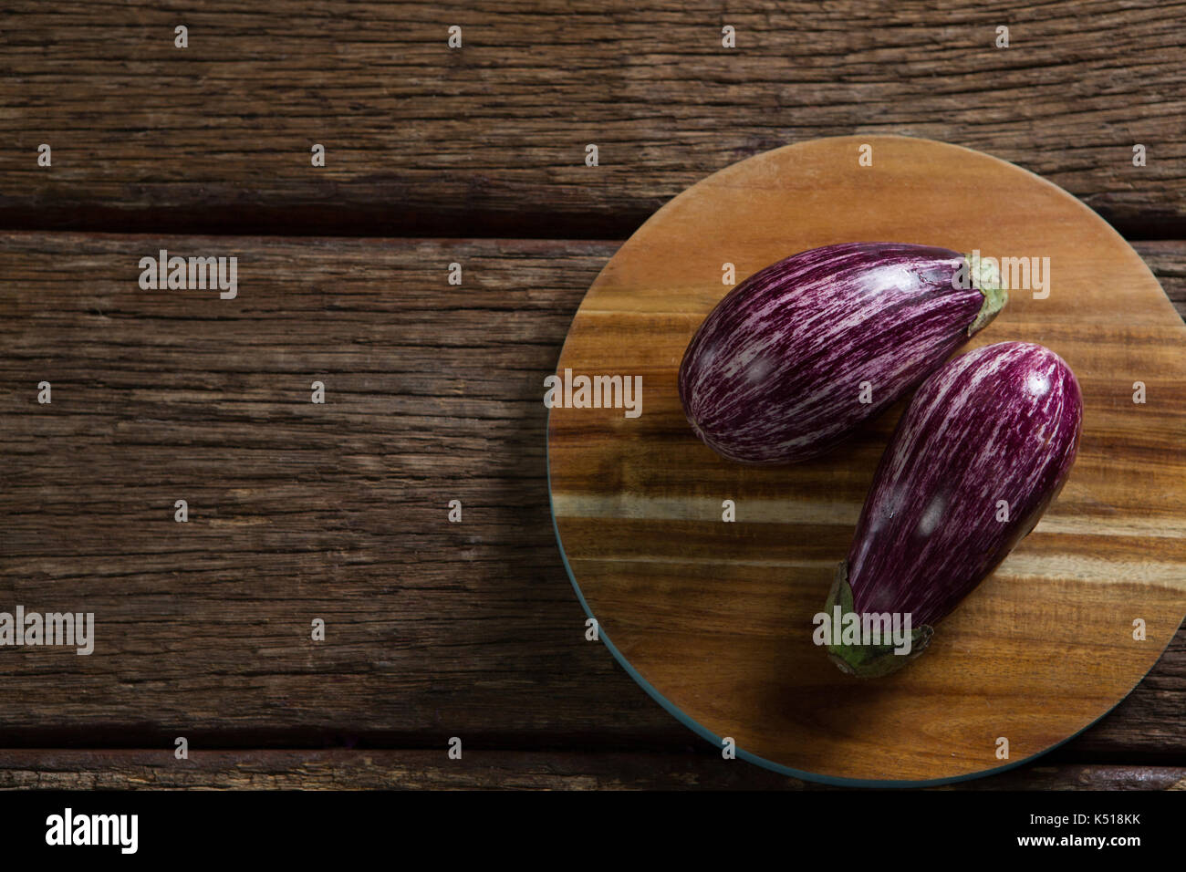 Overhead of two eggplant on chopping board Stock Photo - Alamy