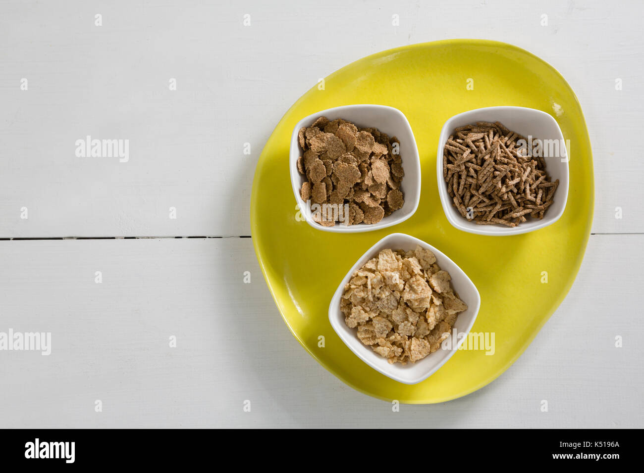 Wheat flakes and cereal bran sticks in bowl on white background Stock ...