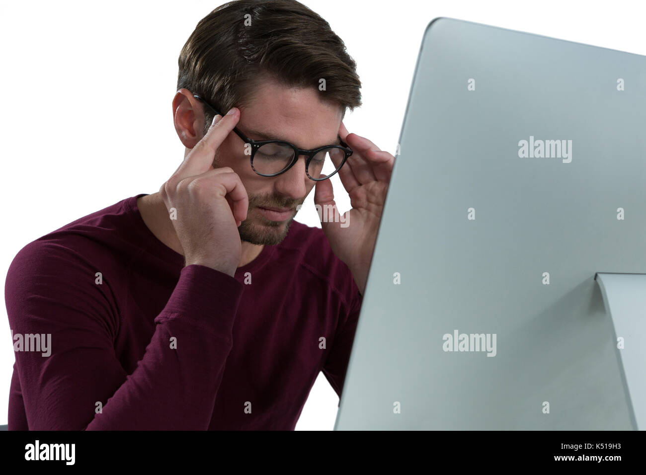 Stressed man sitting at desk against white background Stock Photo - Alamy
