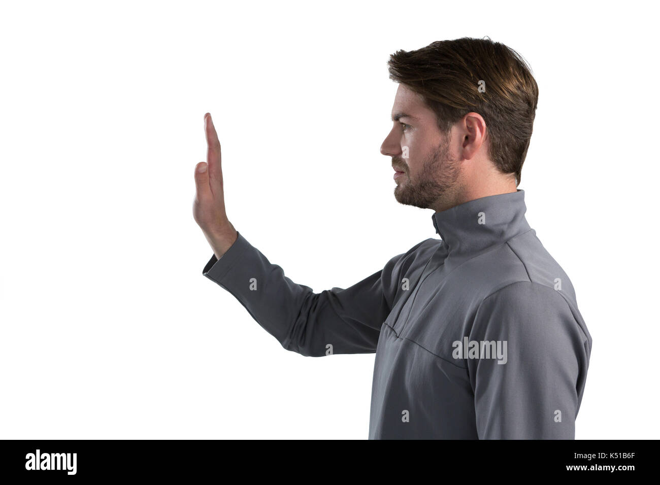 Handsome man gesturing stop sign against white background Stock Photo ...