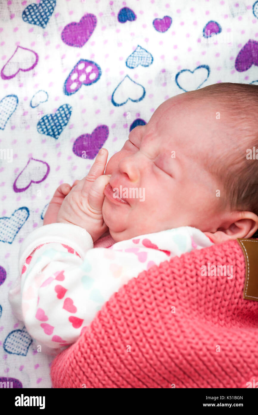 Newborn baby frowning while sleeping in the crib Stock Photo - Alamy