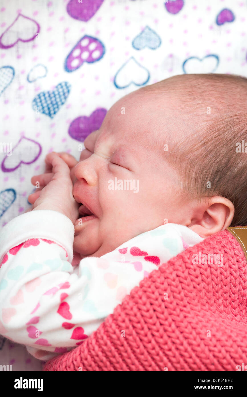 Newborn baby frowning while sleeping in the crib Stock Photo - Alamy