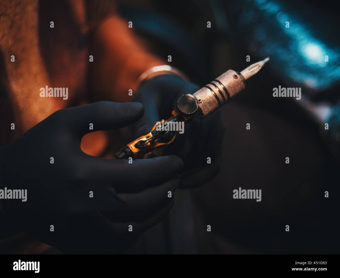 Tattooist does tattoo a client with a tattoo machine close up. Process ...