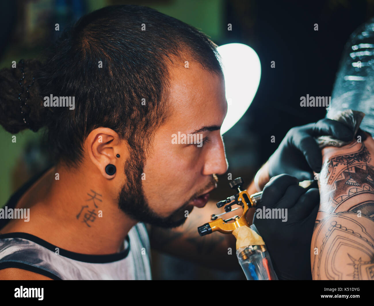 Portrait of man tattoo master with dreadlocks showing process of ...