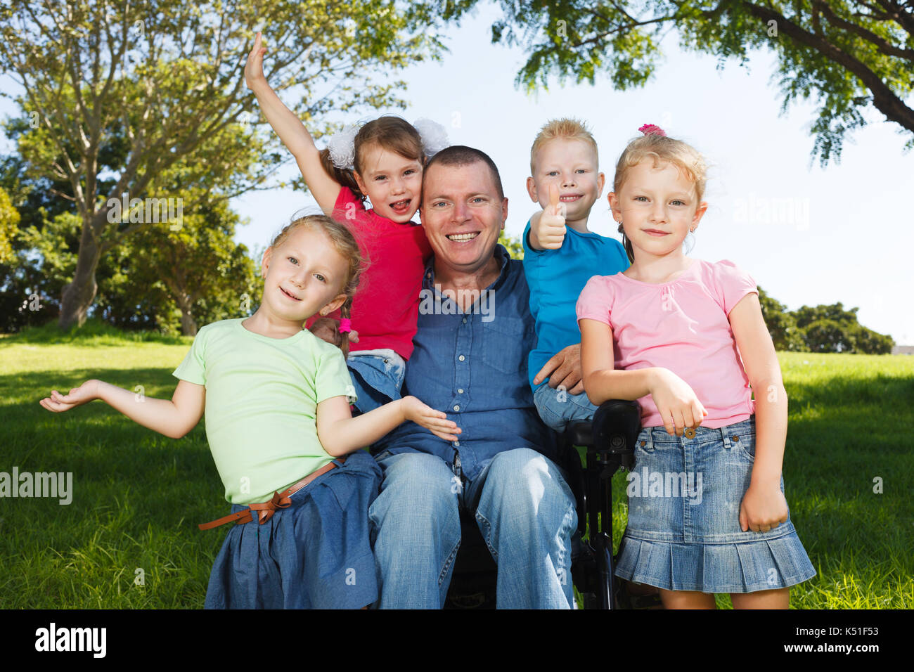 Disabled father with children showing unity Stock Photo - Alamy