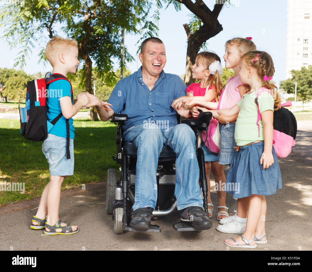Disabled father with children showing unity Stock Photo - Alamy