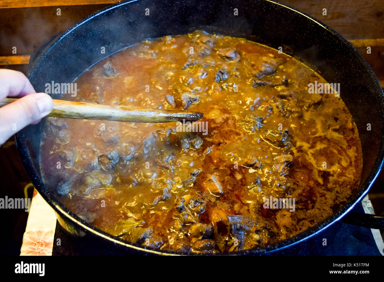 Male hand mixing a stew Stock Photo - Alamy