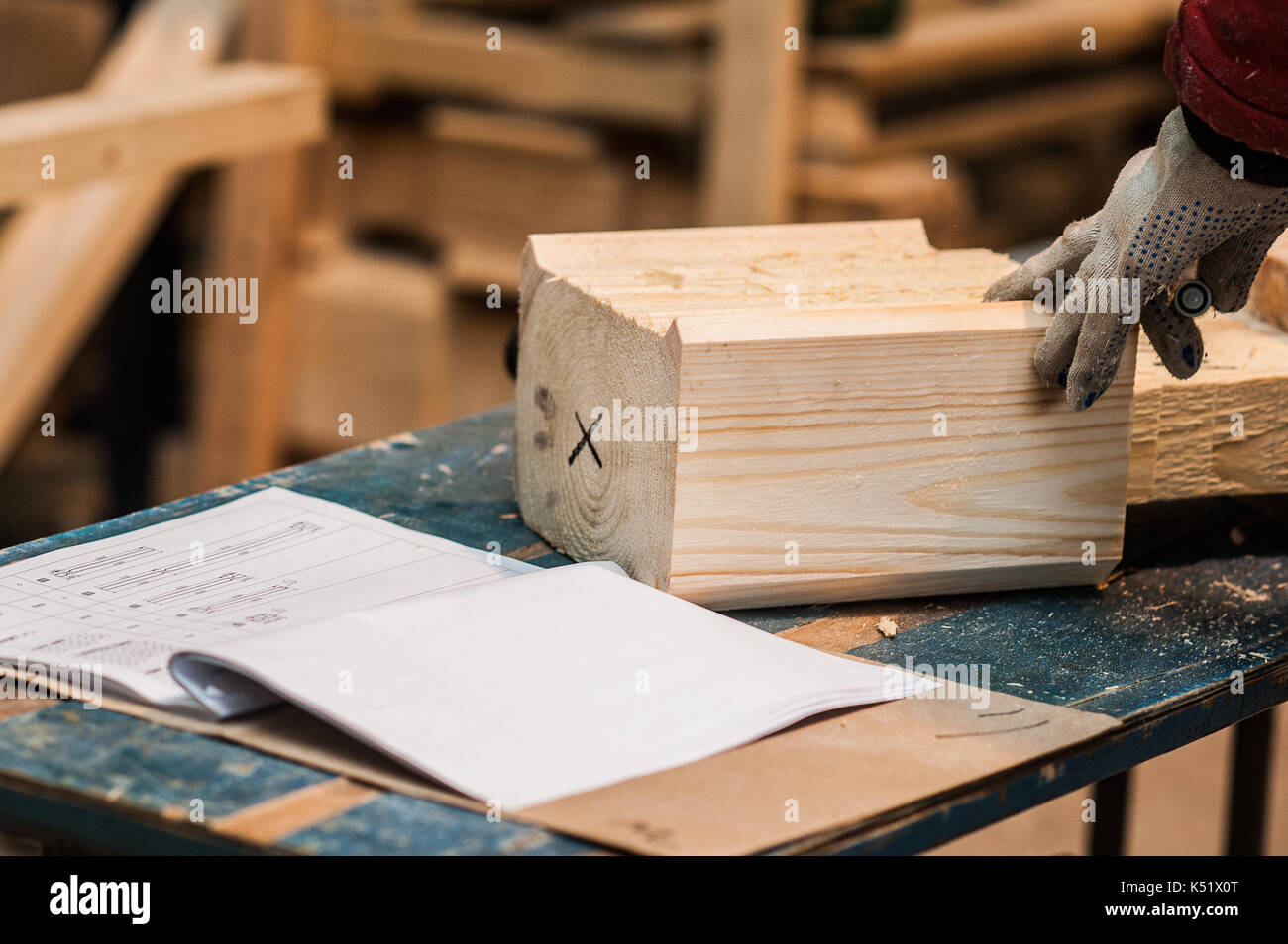 Hands of a hard worker mark a detail of a wooden beam with a marker ...