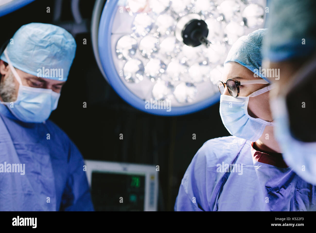 Surgeons wearing medical mask performing surgery in operation theater ...