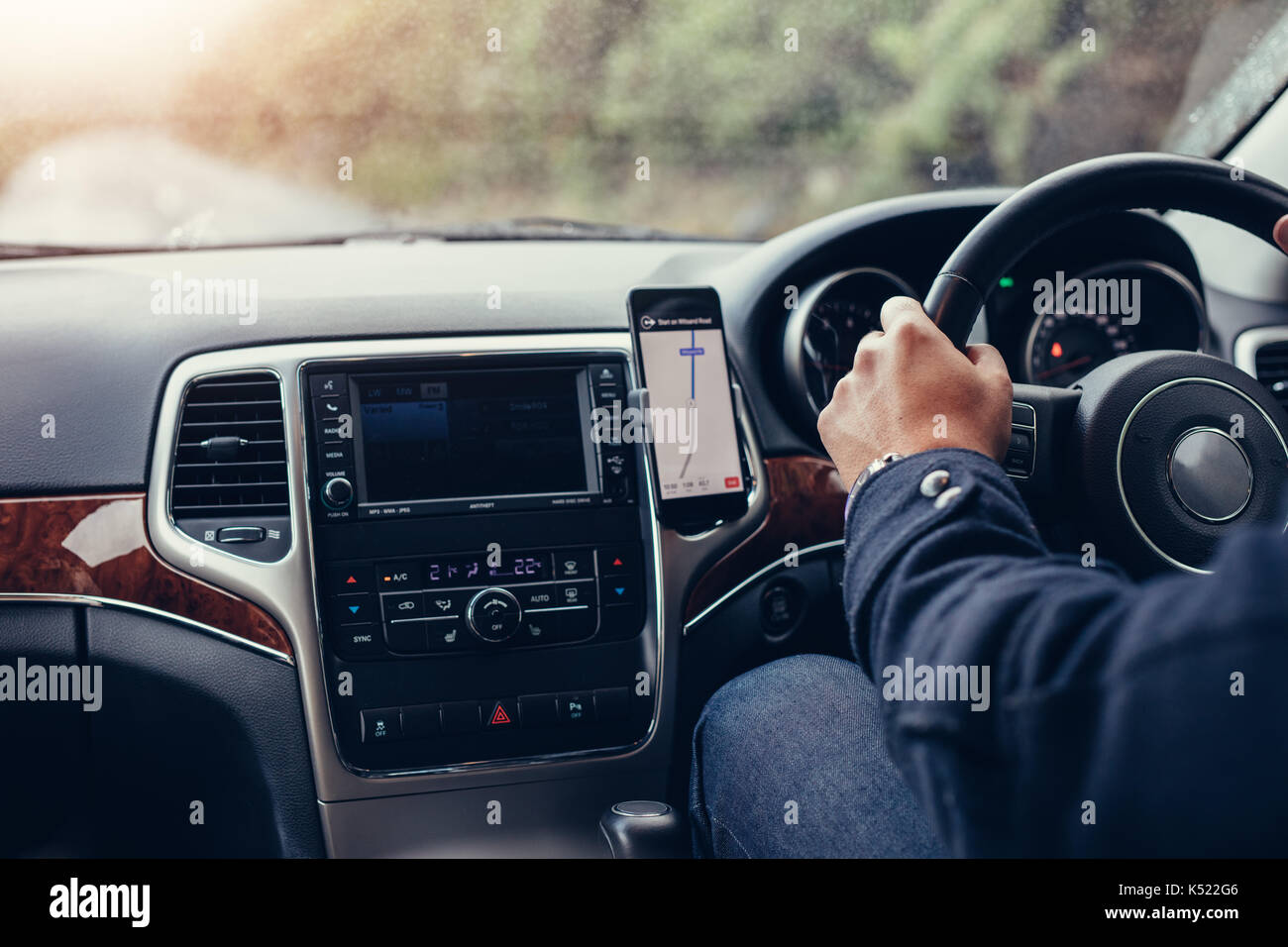 Man driving car with mobile navigation system. Male using mobile phone ...