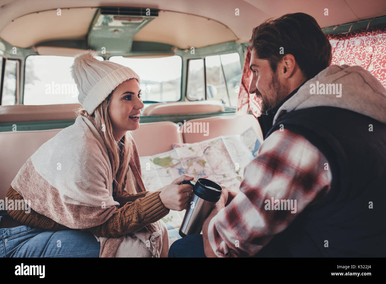 Two friends on a road trip sitting inside the van talking and having ...