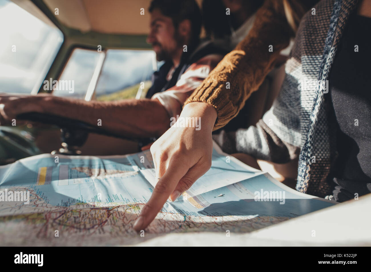 Friends on road trip looking at map for directions. Close up of female ...