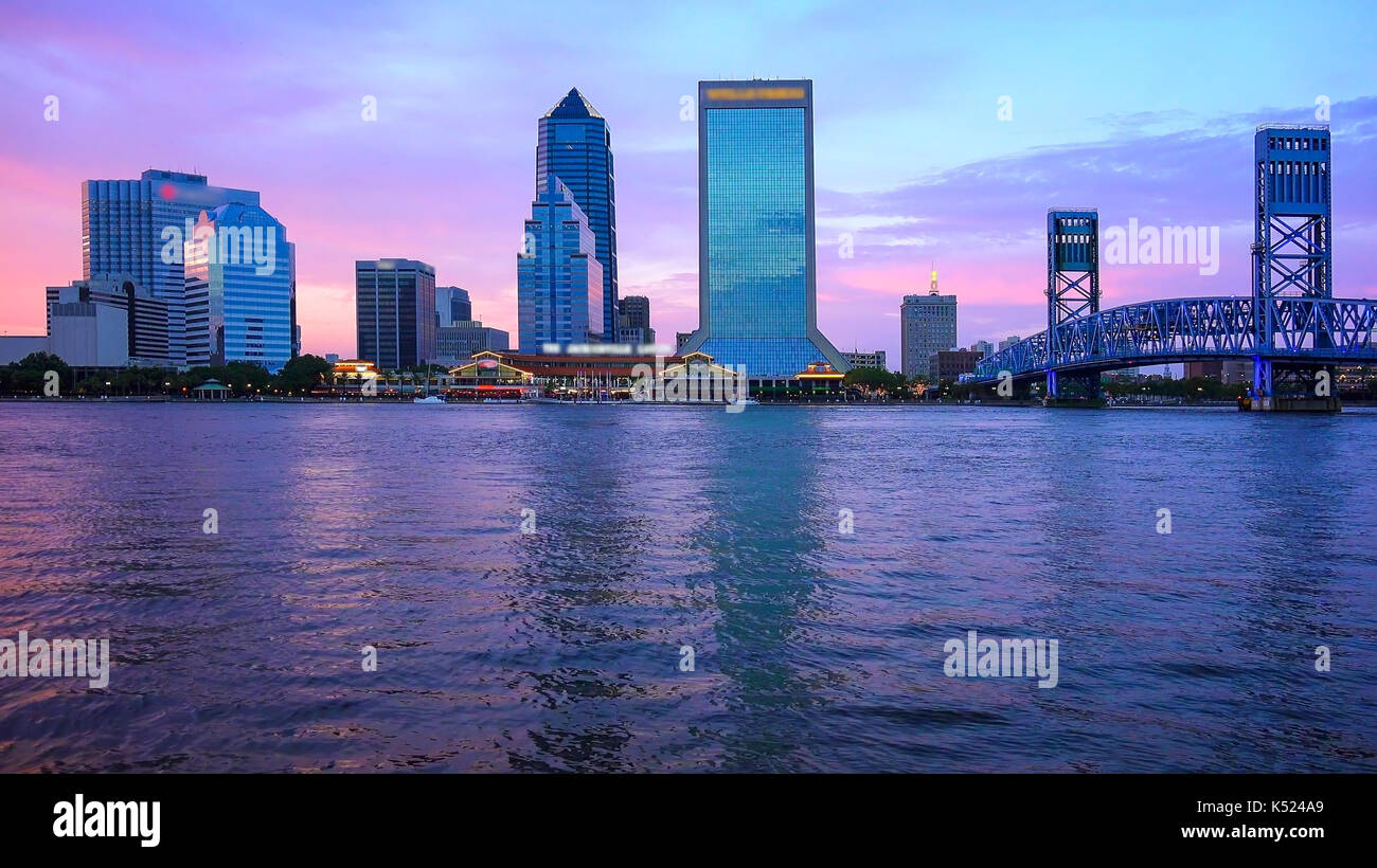 Jacksonville, Florida city skyline over the St. John's River at sunset (logos blurred for ...
