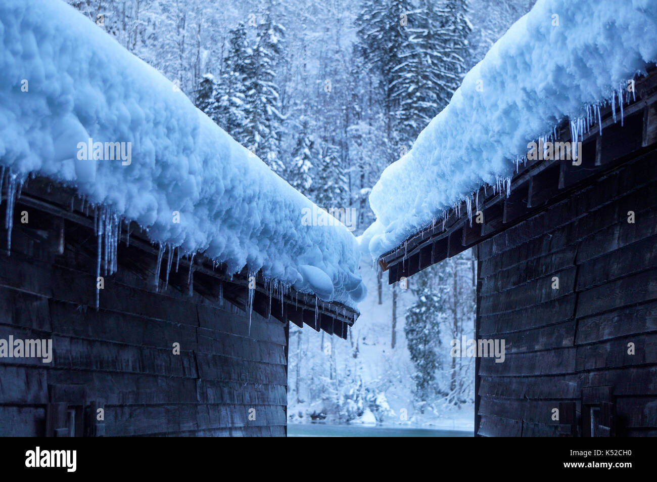 Snow and icicles on the roof Stock Photo - Alamy