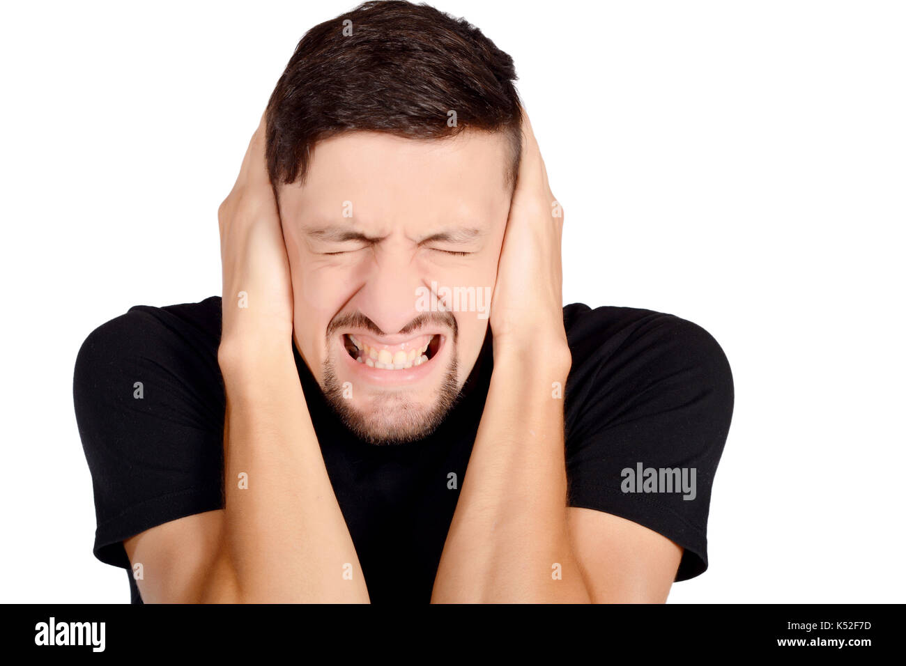 Portrait of a young man covering his ears. Isolated white background ...