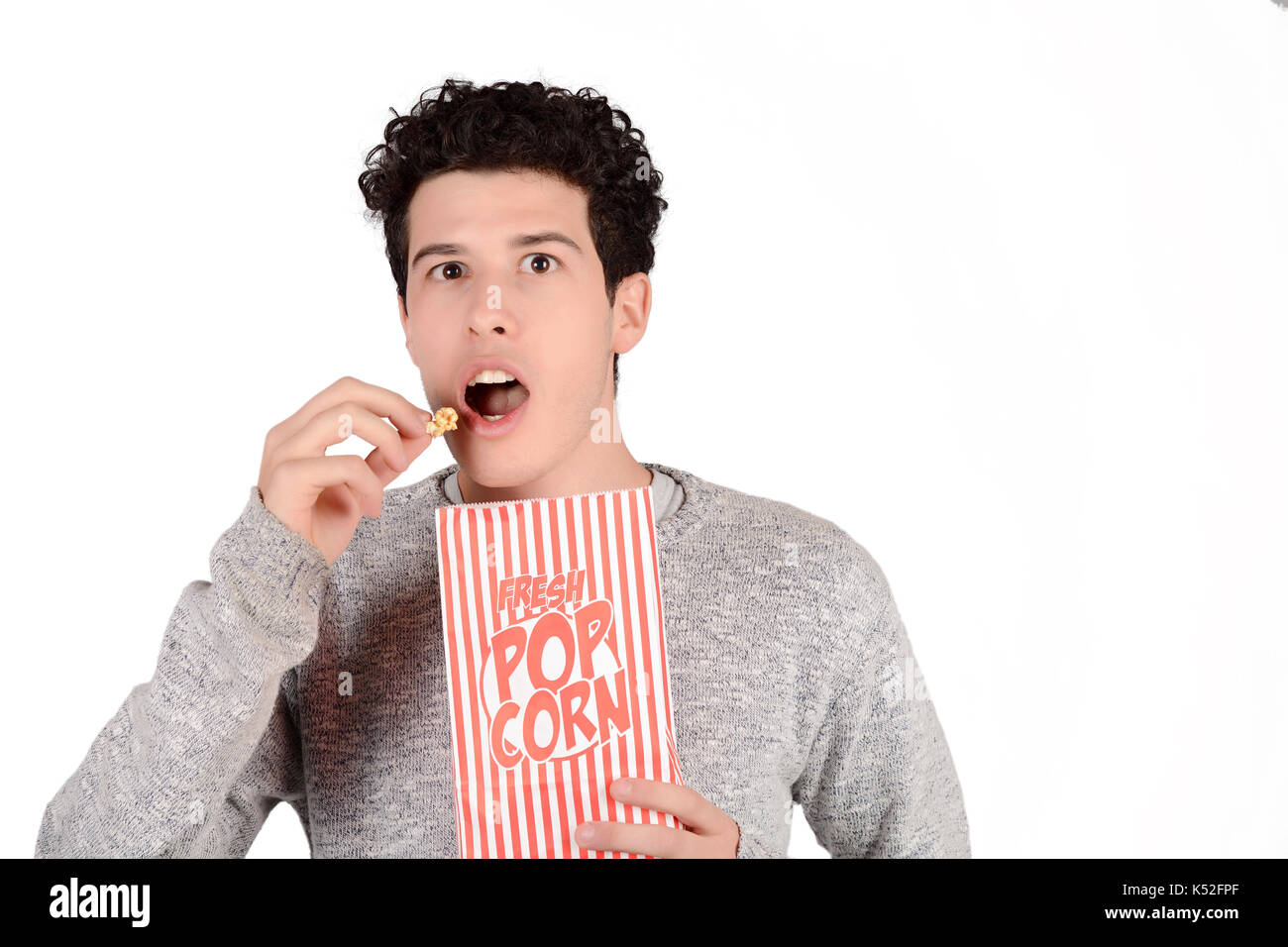 Portrait of young man eating popcorn. Isolated white background Stock ...