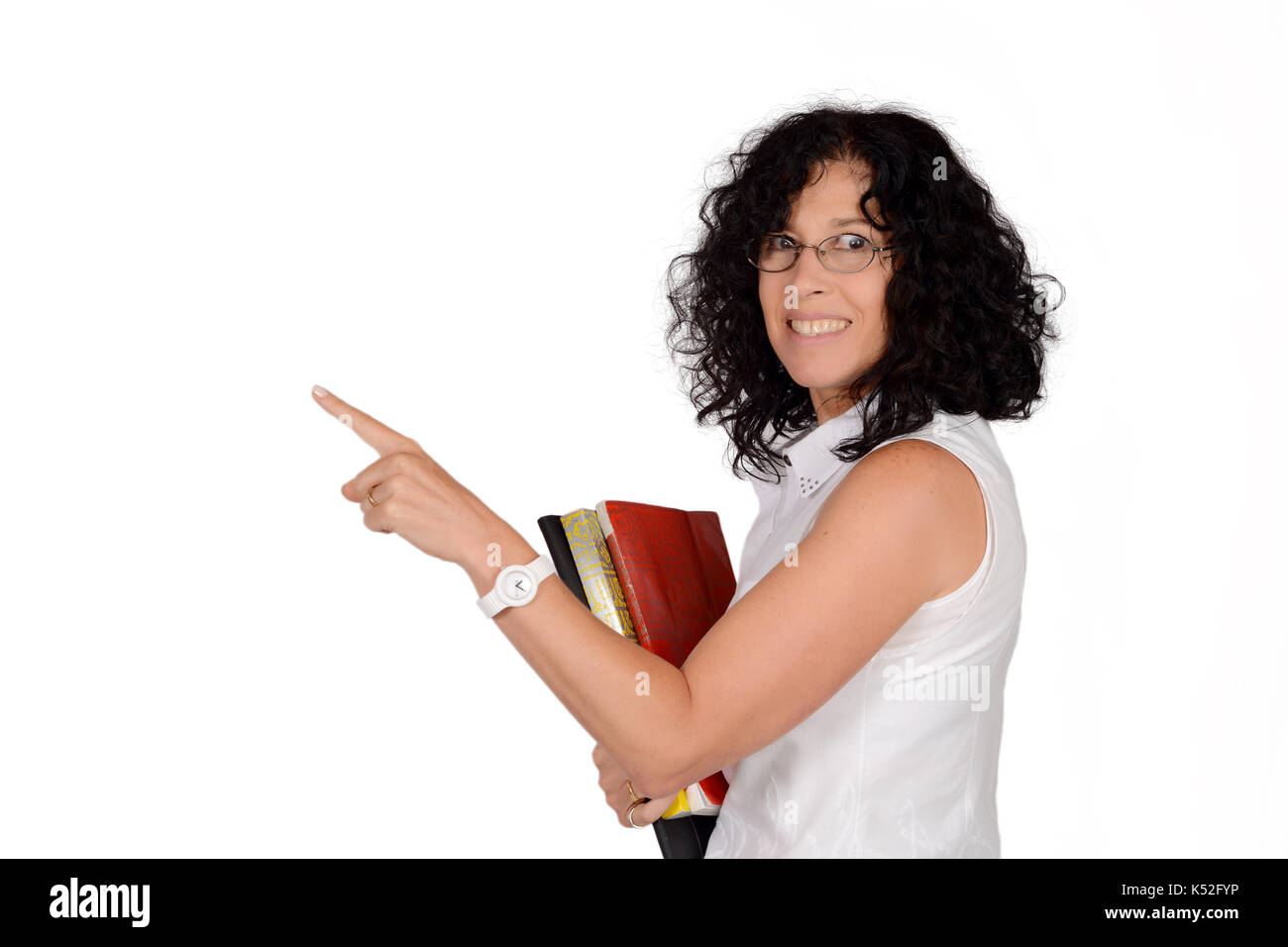 Portrait of beautiful school teacher holding books and pointing ...