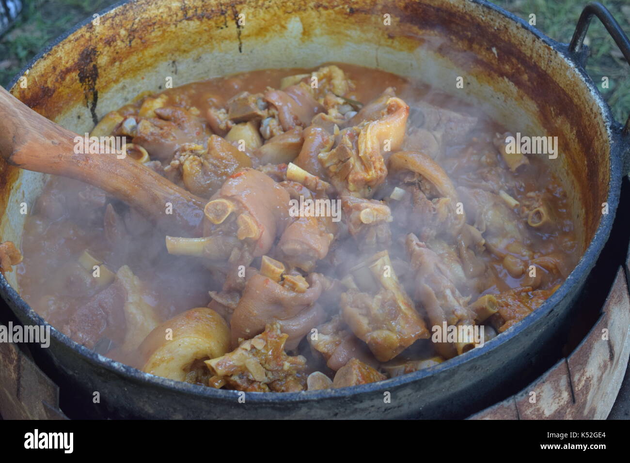 Wooden spoon mixing a larger pot of stew Stock Photo - Alamy