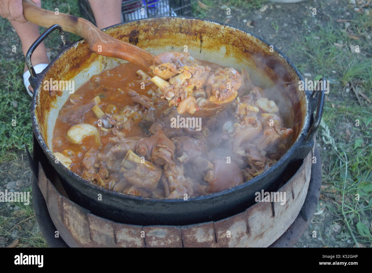 Wooden spoon mixing a large pot of lamb stew Stock Photo - Alamy