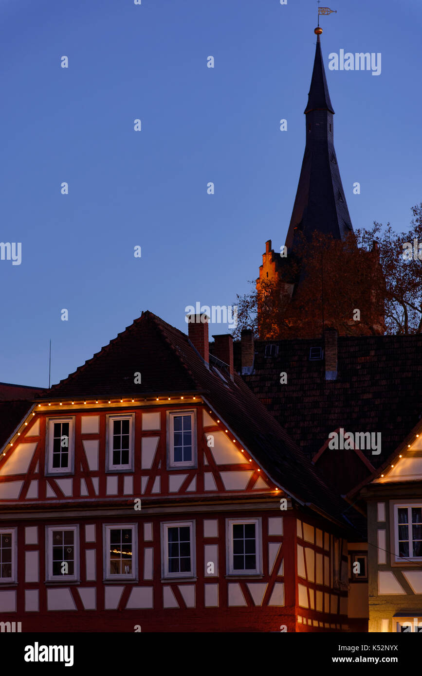 Festive illuminated half-timbered house and castle tower in the old ...