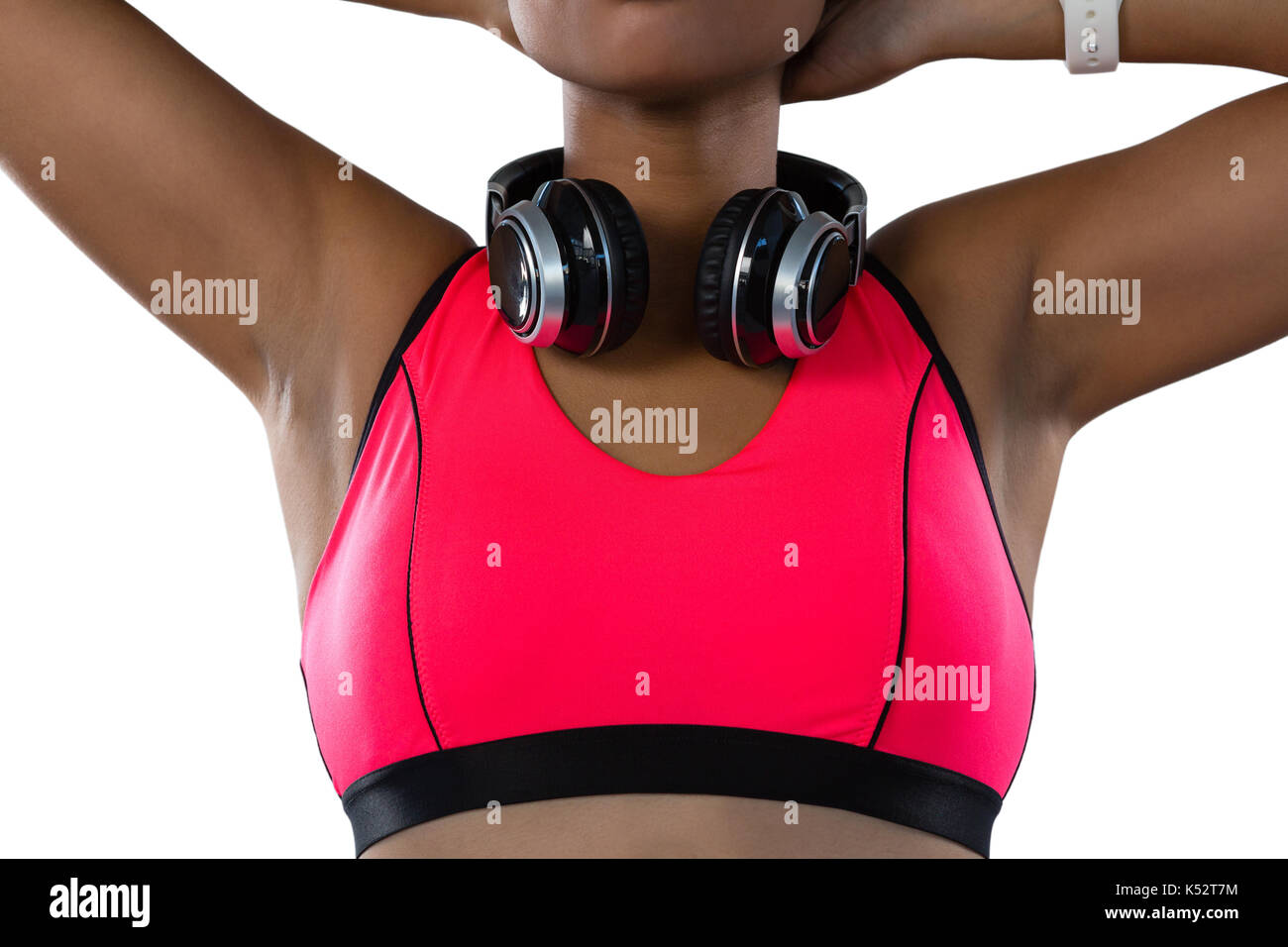 Mid section of female athlete with headphones against white background ...
