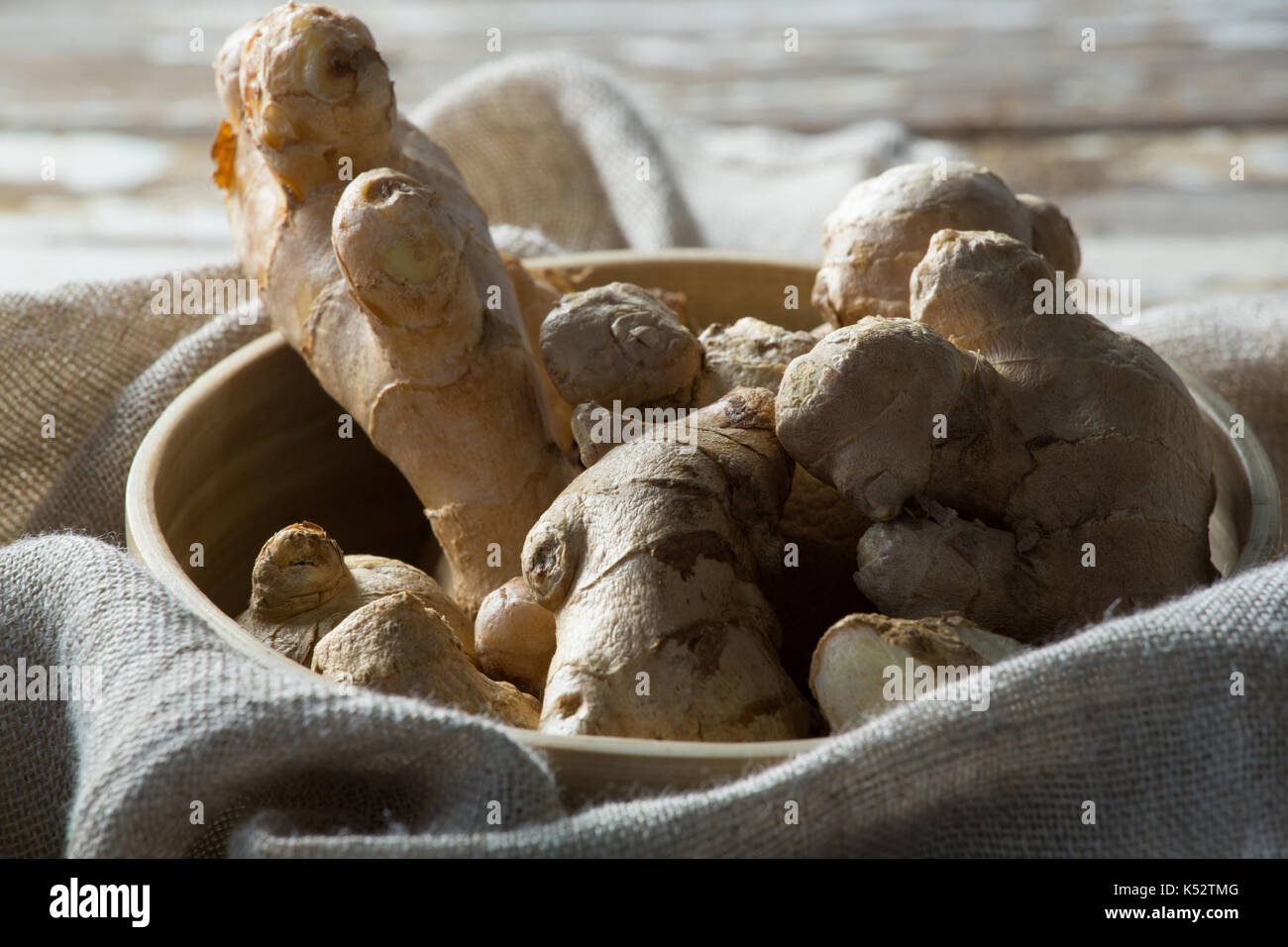 Close up of fresh gingers in bowl on burlap over table Stock Photo - Alamy