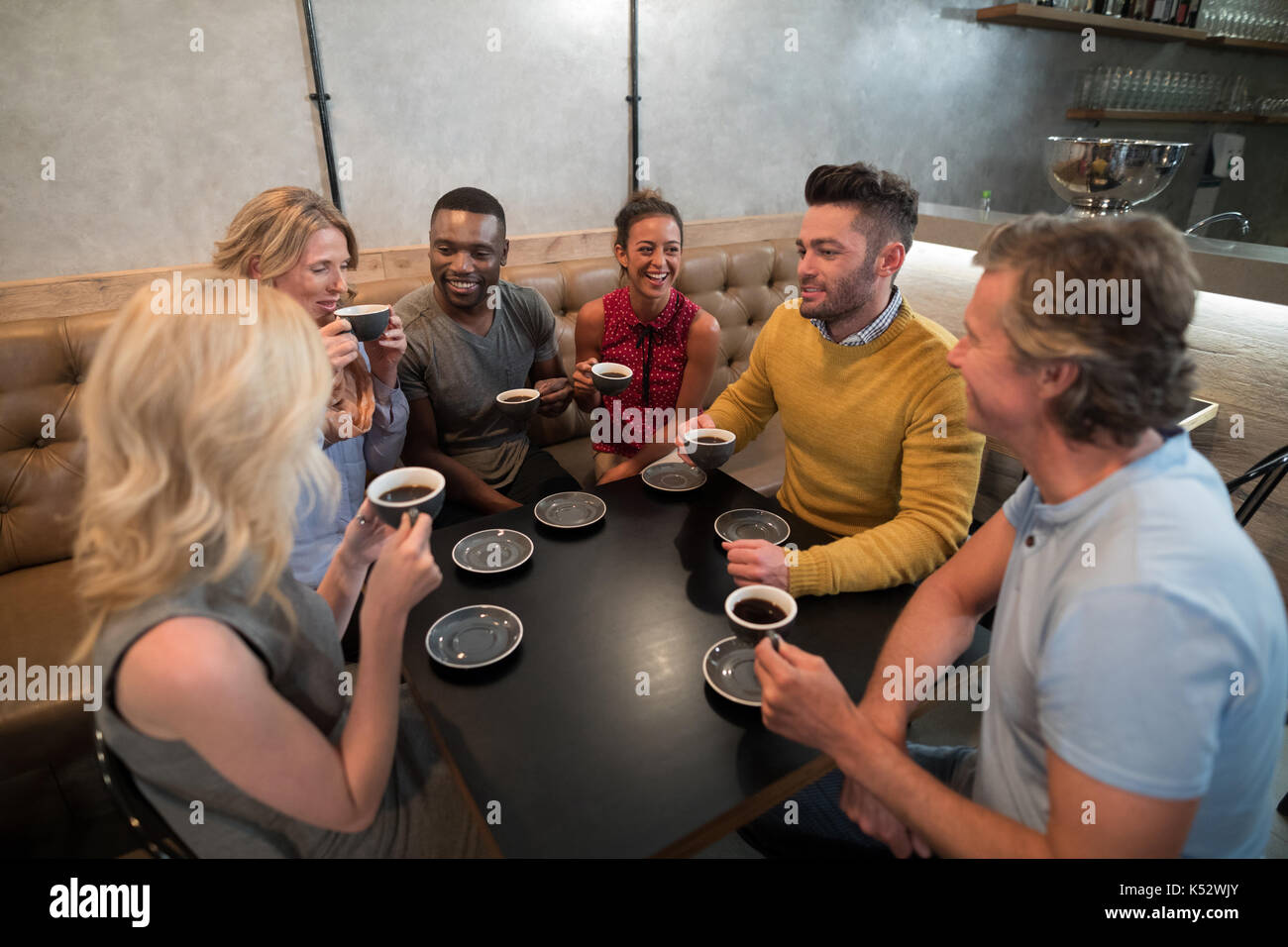 Happy friends interacting while having coffee at cafe Stock Photo - Alamy
