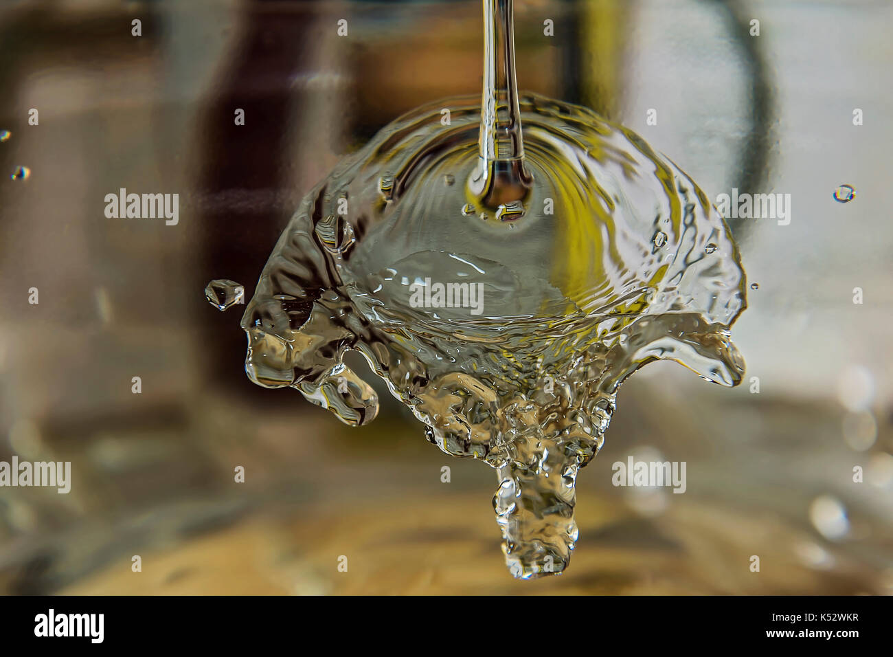 A stream of water splits about a transparent surface and flows down ...