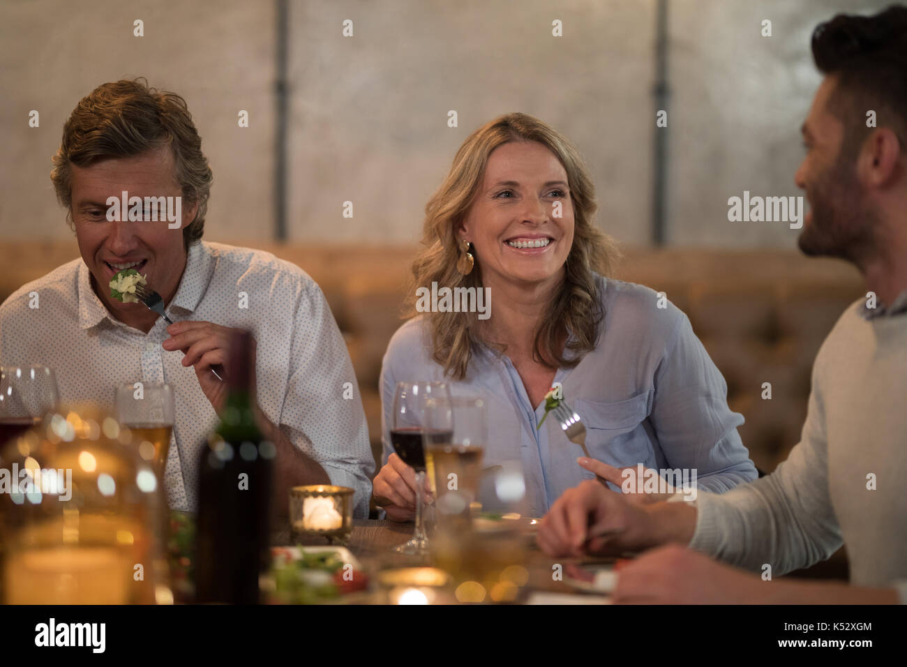 Happy friends interacting while dining in restaurant Stock Photo - Alamy
