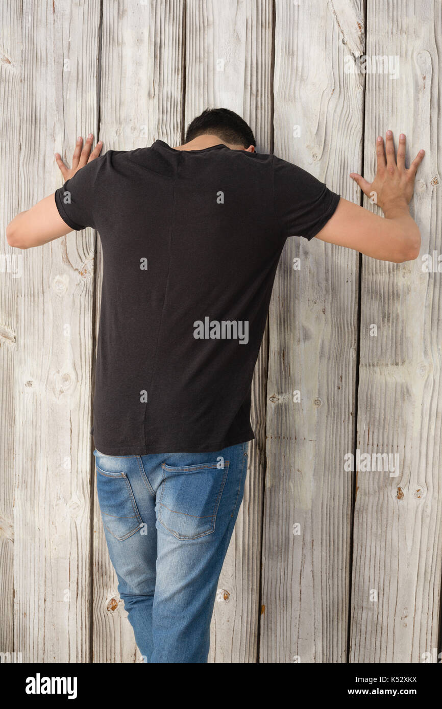 Rear view of man leaning on wooden wall Stock Photo - Alamy