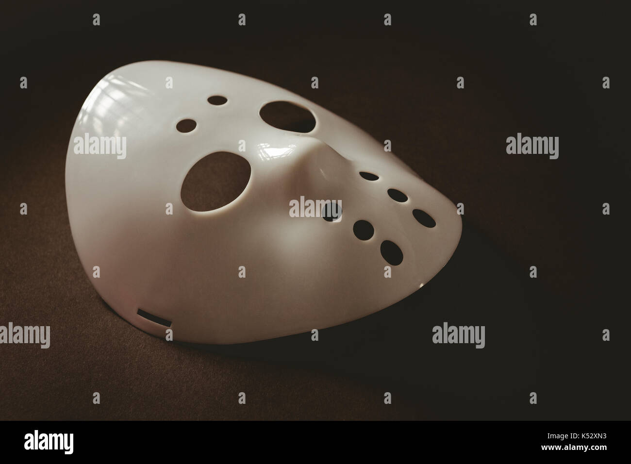High angle view of evil mask over brown background Stock Photo - Alamy