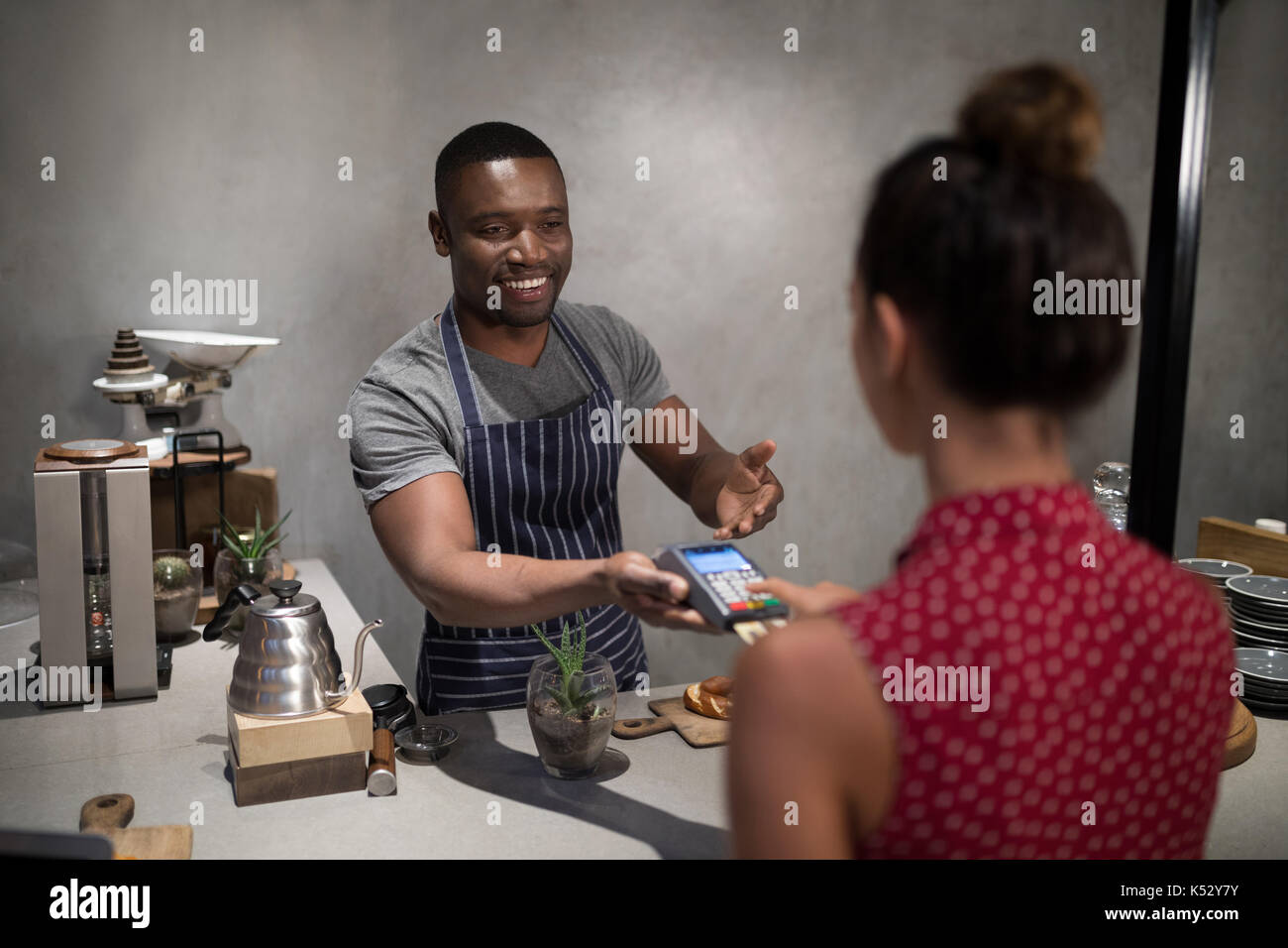 Customer making payment through credit card at counter in cafe Stock ...