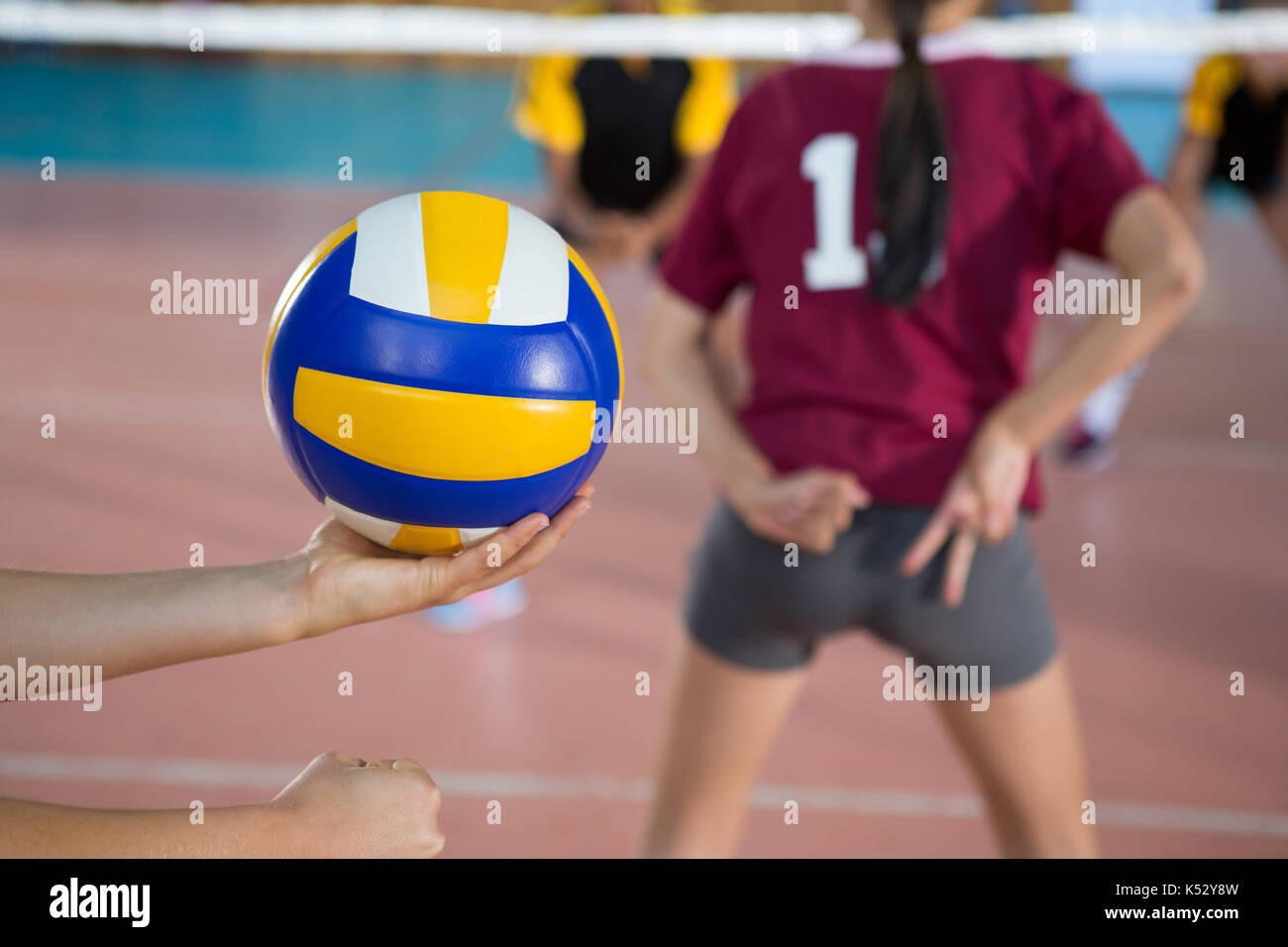 Female volleyball players playing volleyball in the court Stock Photo ...