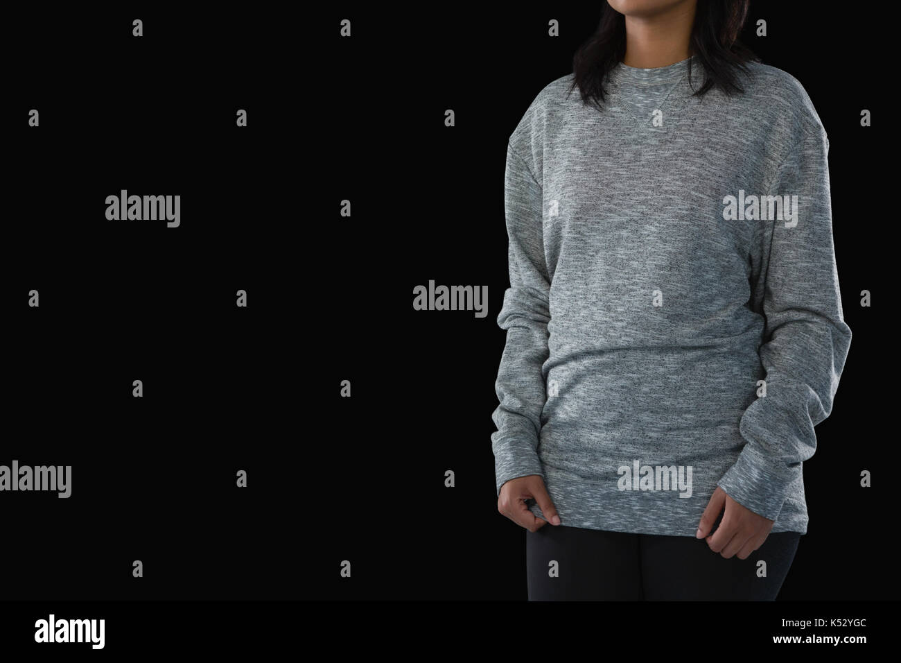 Mid section of young woman standing over black background Stock Photo ...