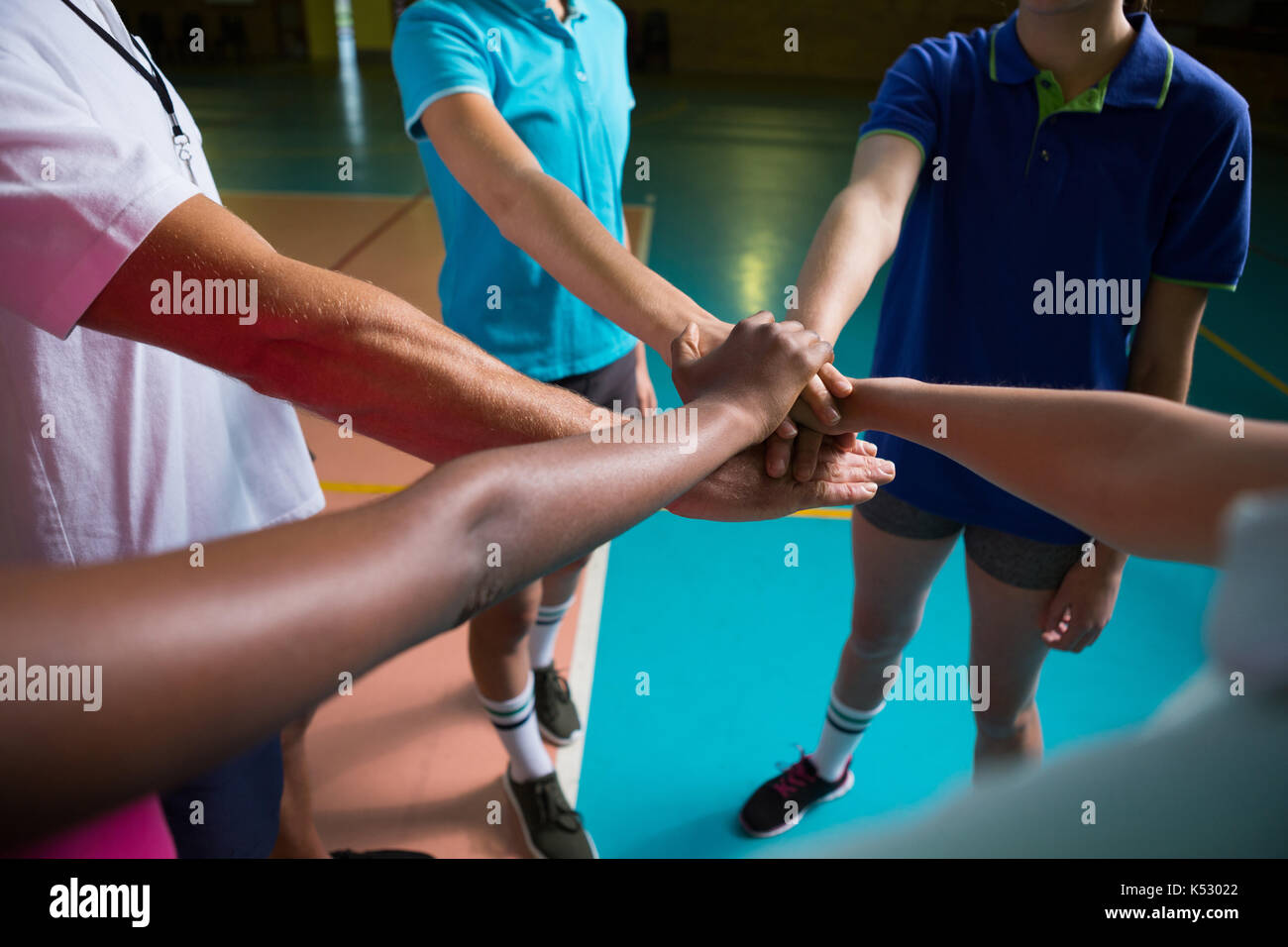 Volleyball players and coach forming hand stack in the court Stock ...