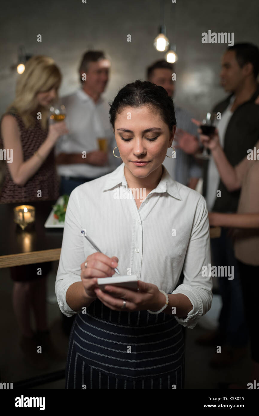 Beautiful waitress writing order in notepad in restaurant Stock Photo ...