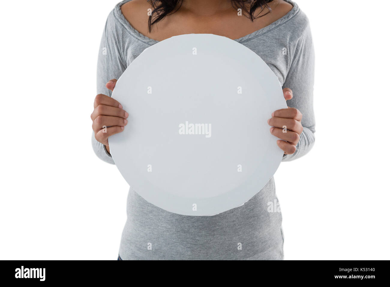 Mid section of woman holding circle shaped placard against white ...