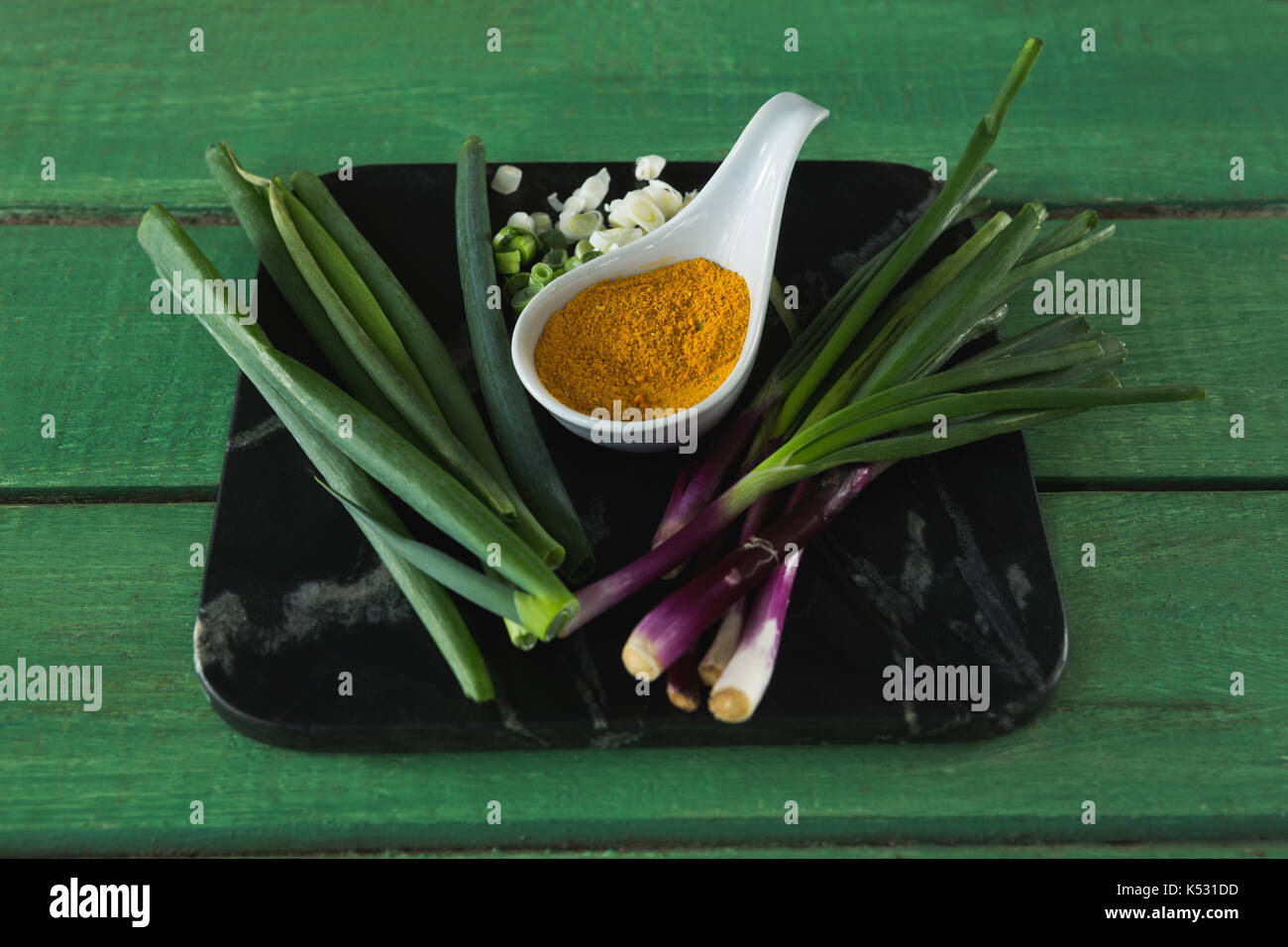 Close-up of scallions and turmeric powder on board Stock Photo - Alamy