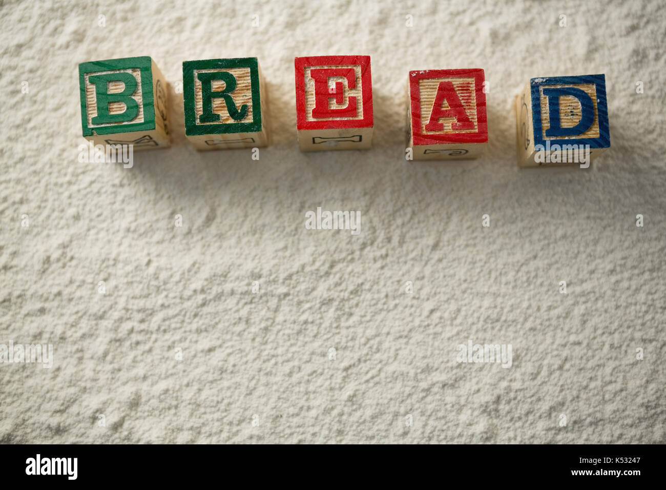 Overhead view of bread text made with wooden blocks on flour Stock ...