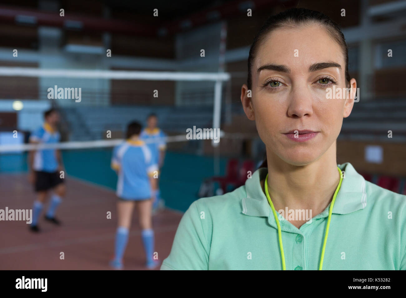 Portrait of confident female coach with volleyball players in ...
