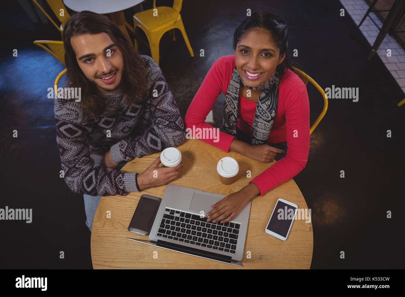 Portrait of young friends with laptop at table in cafe Stock Photo - Alamy