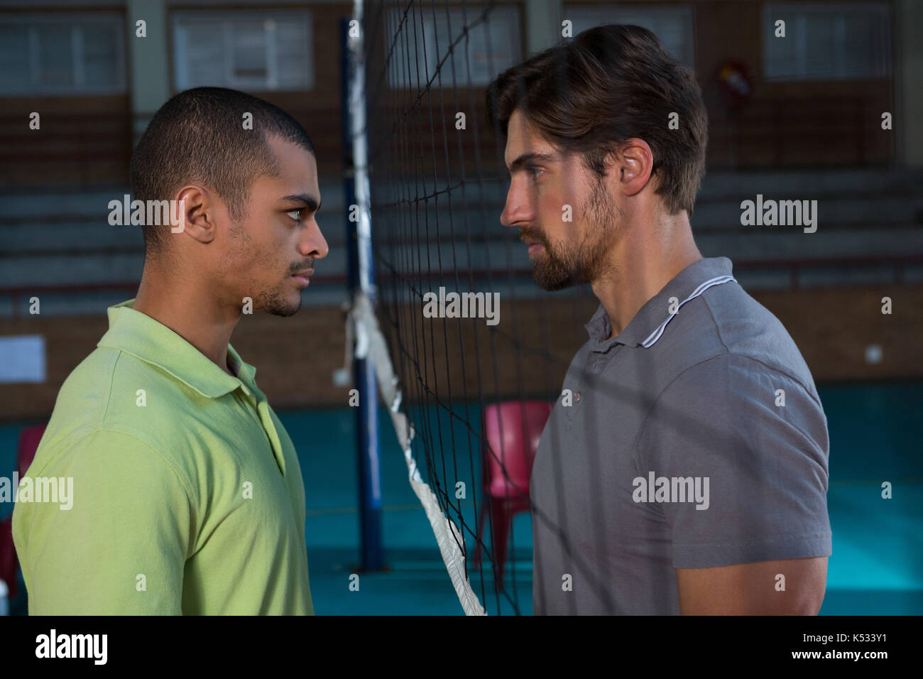 Side view of aggressive male volleyball players looking each other ...