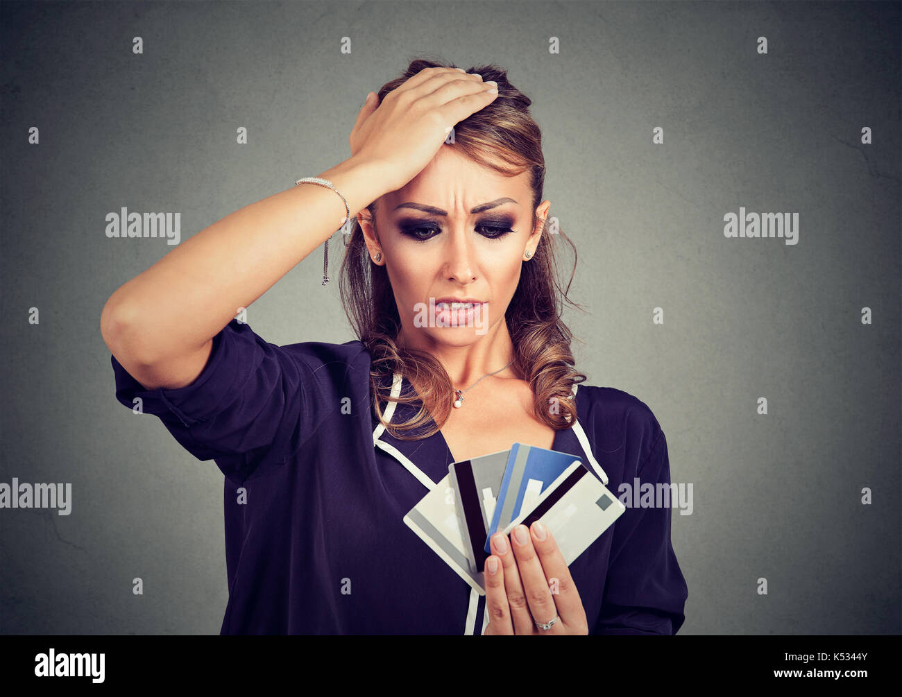 Confused stressed woman looking at too many credit cards Stock Photo ...