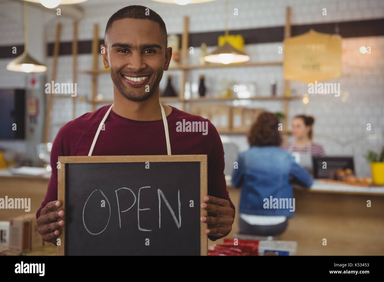 Portrait of smiling owner with open sign standing in cafe Stock Photo ...