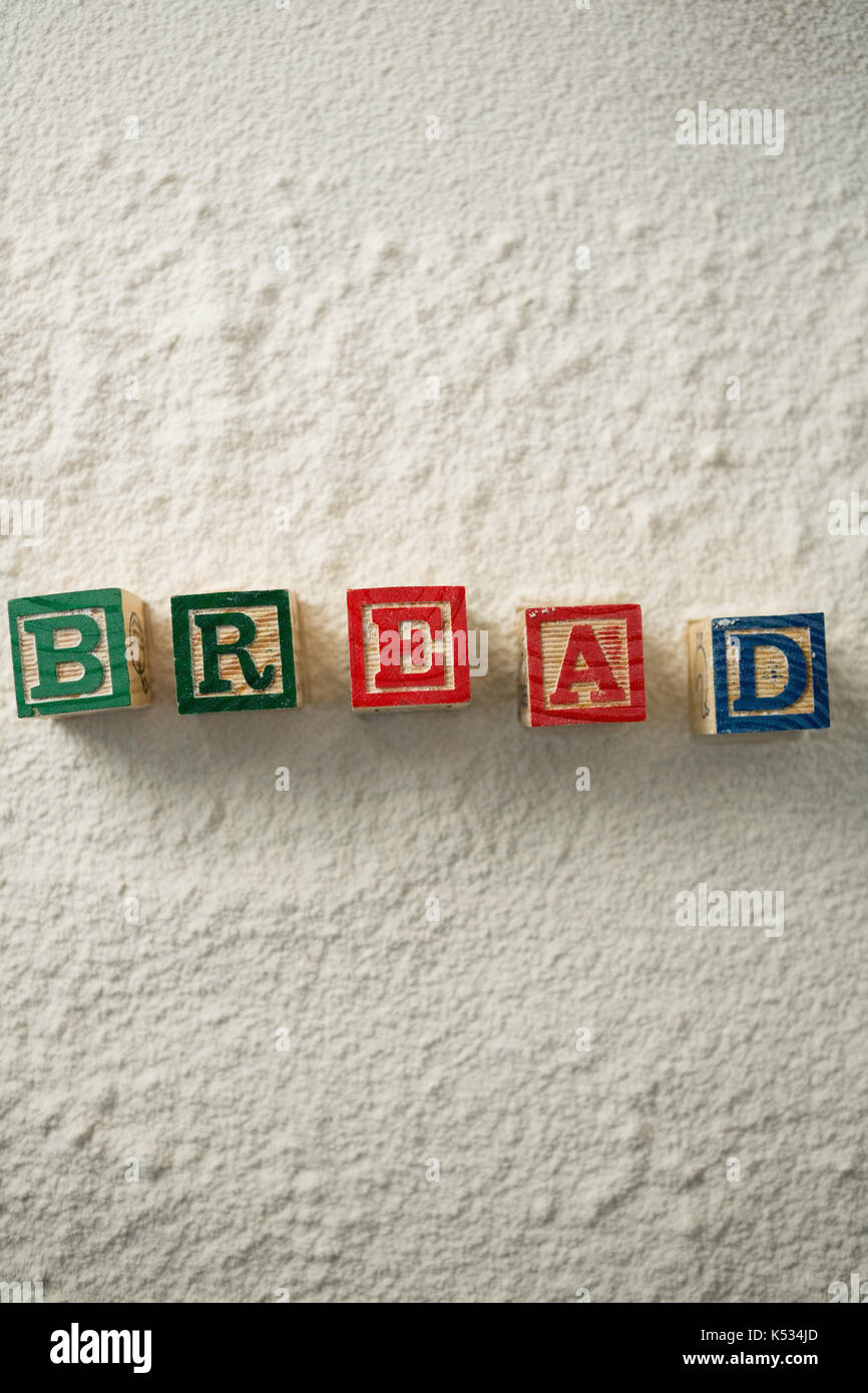 Overhead view of bread text made with blocks on flour Stock Photo - Alamy