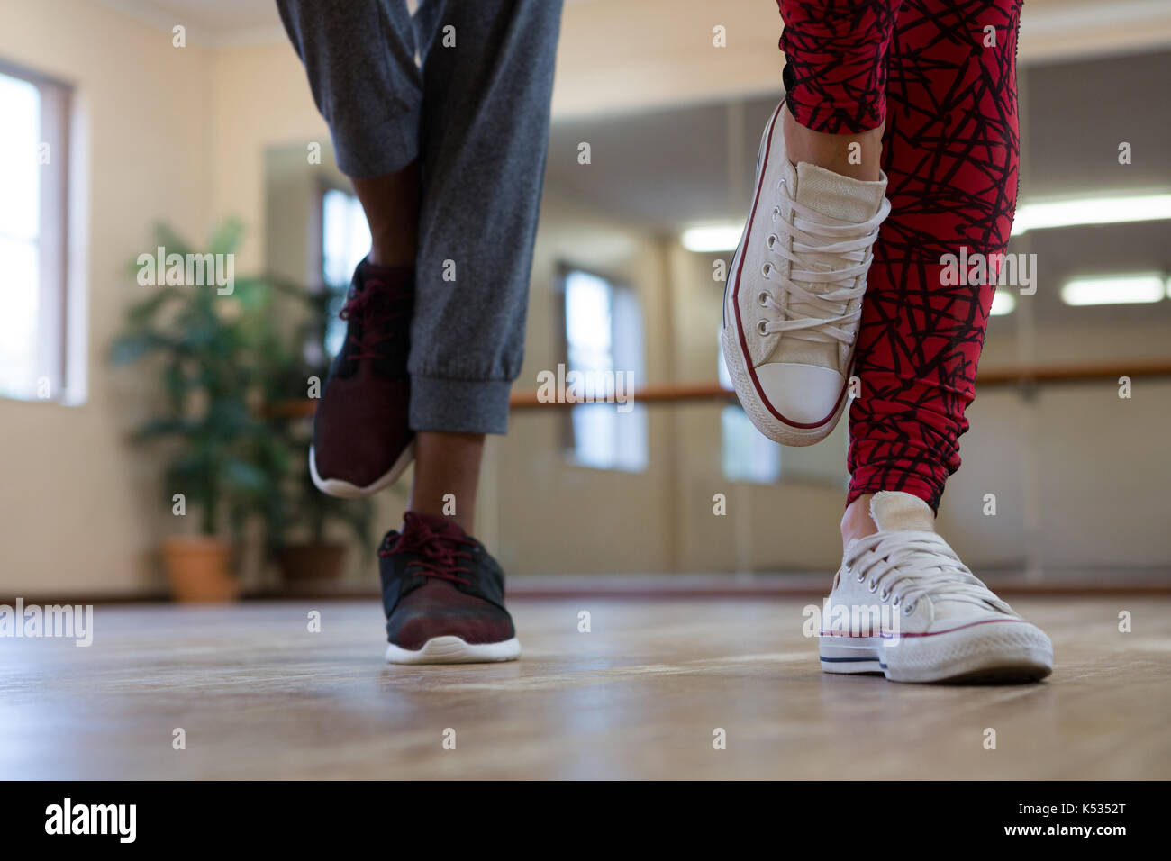 Low section of friends practicing dance on wooden floor Stock Photo - Alamy