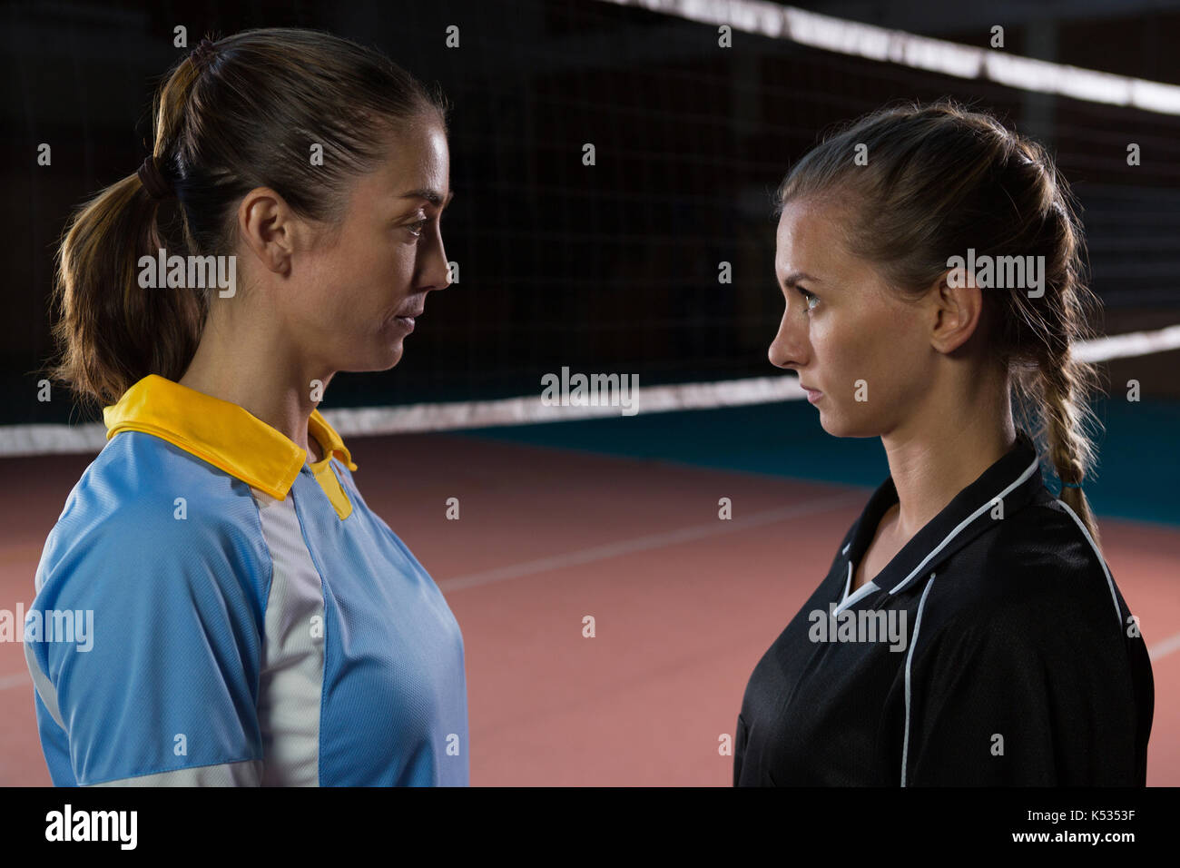 Side view of female volleyball players looking each other while ...